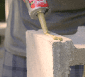 Man stacks cinder blocks then adds one more item to make modern bench ...