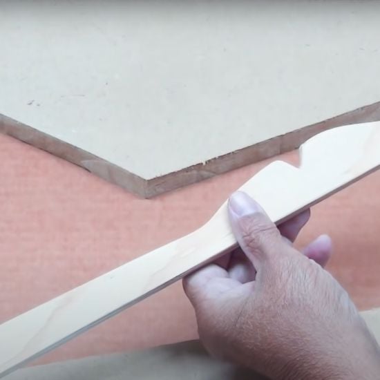 Woman uses tick stick to demostrate old carpentry hack for copying patterns