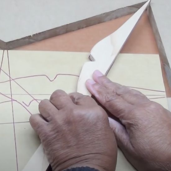 Woman uses tick stick to demostrate old carpentry hack for copying patterns