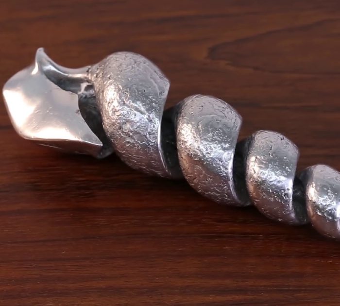 Man pours molten metal into a seashell to create a stunning piece of art