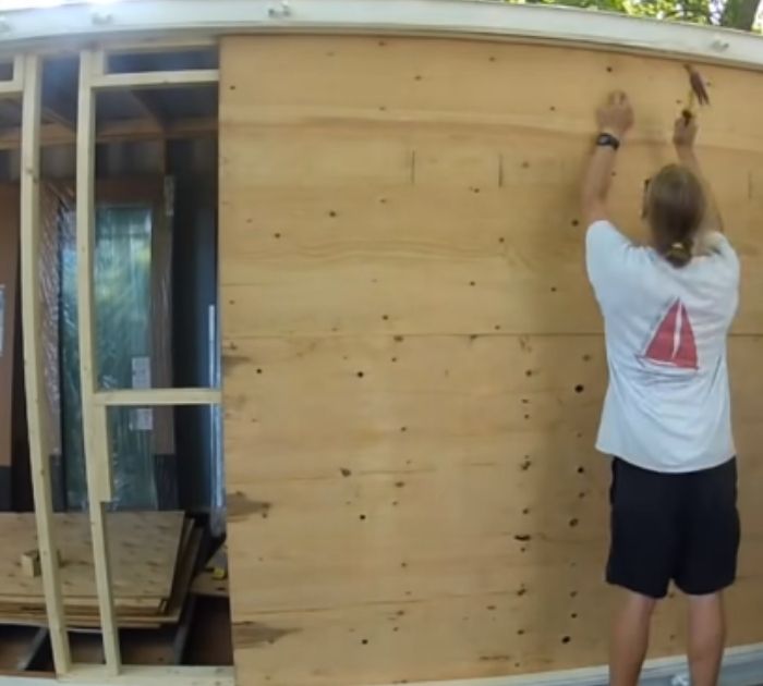 Man builds genius home out of shipping container that sits over a stream