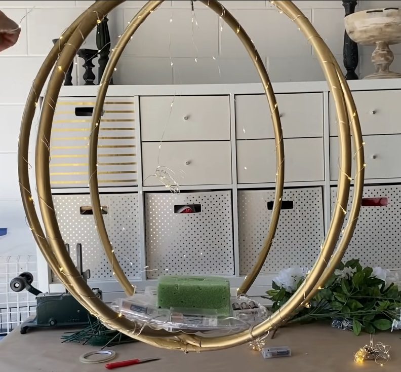 Woman covers 3 hula hoops in gold paint for fairytale garden idea