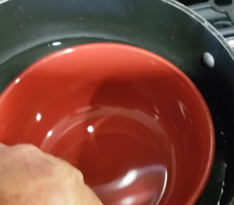 Man shows how to distill water by flipping lid upside down over pot of ...