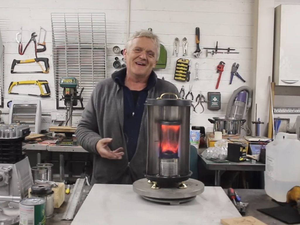 Man attaches tin cans and cake pans to aluminum sheet metal for ...