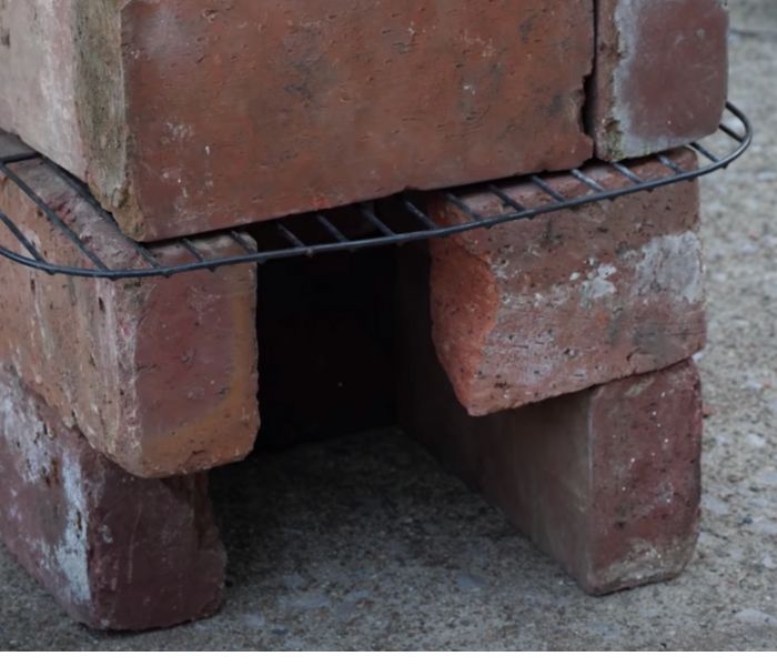 Homesteader stacks old bricks to make simple outdoor cook stove
