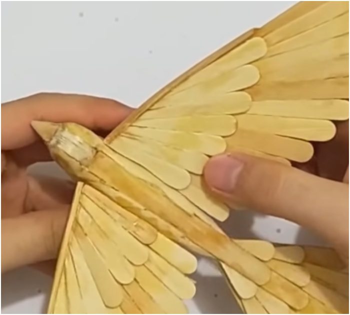Man uses glue and popsicle sticks to make beautiful flying bird ornaments